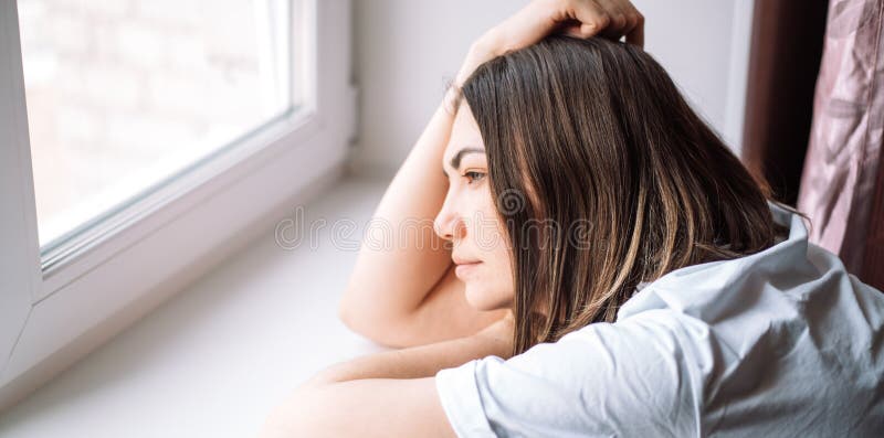 Sad Lady Lay Down on the Windowsill and Looks Out the Window Stock ...