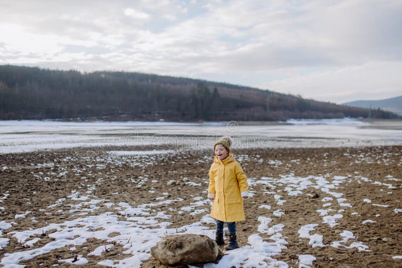 Sad Little Boy with Down Running Outside by Lake in Winter. Stock Image ...