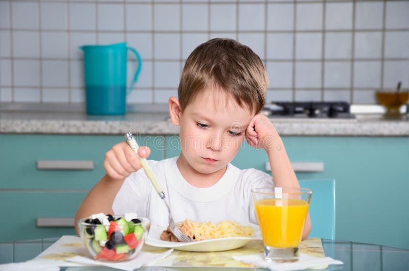 Sad Little Boy Sits at the Dining Table and Looking in the Plate Stock ...