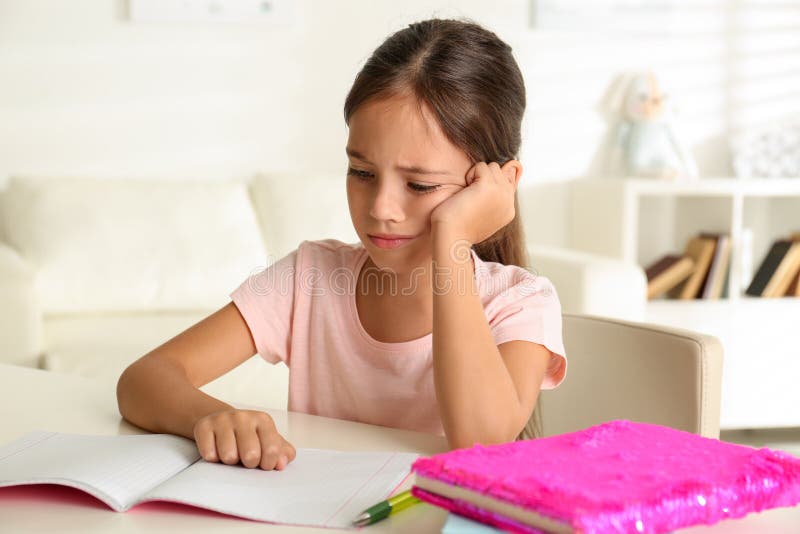 Sad Little Girl Doing Homework at Table Indoors Stock Photo - Image of ...