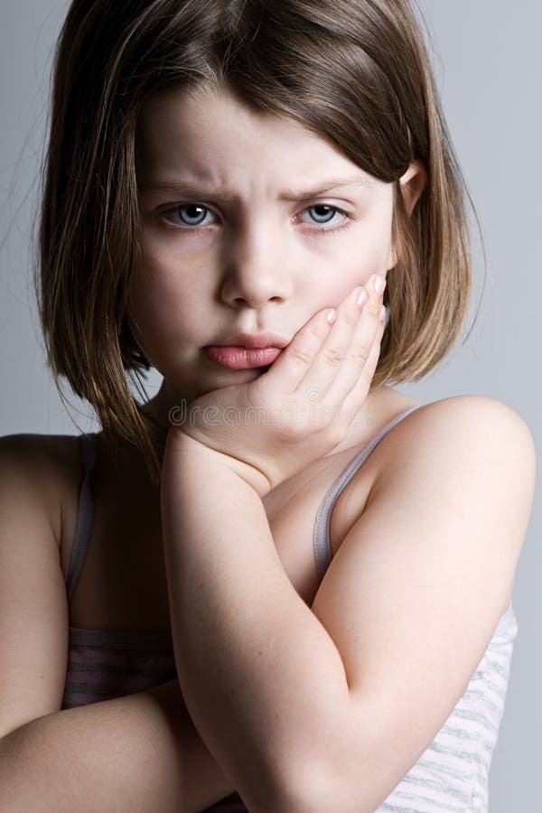 Sad Looking Child Against a Grey Background Stock Photo - Image of ...