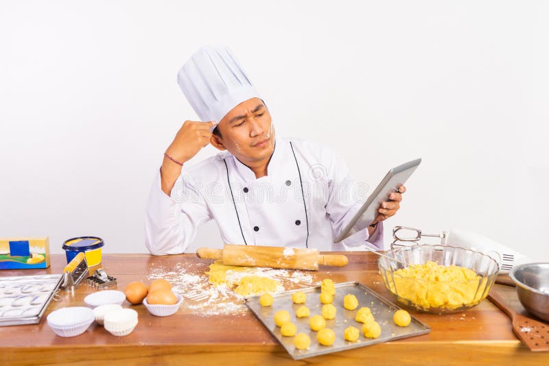 Sad Male Chef Using a Pad while Baking Cake Stock Photo - Image of ...