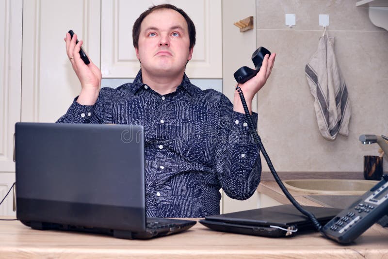 A Sad Man in Depression Sits in the Kitchen at a Laptop in a Home ...