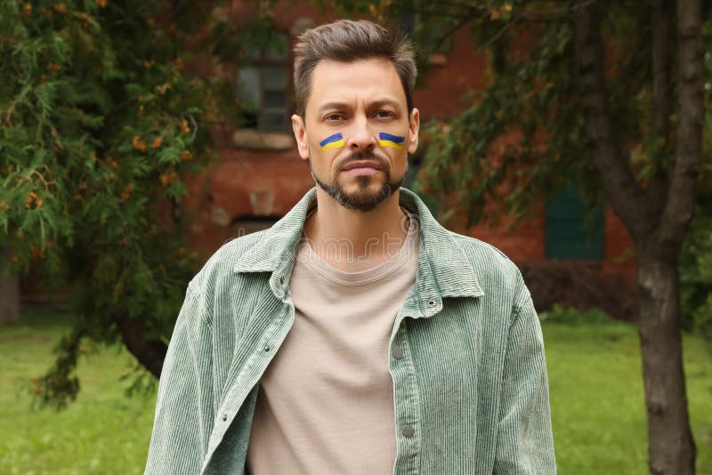 Sad Man with Drawings of Ukrainian Flag on Face Outdoors Stock Photo ...
