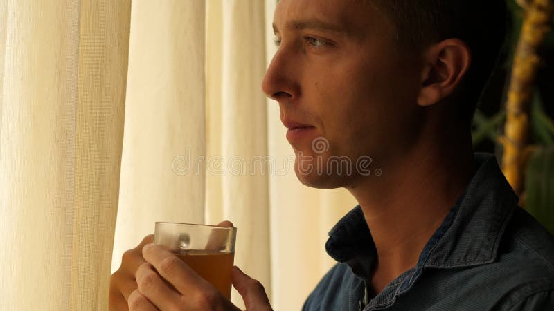 Sad Man Drinking Tea and Looking Out the Window Stock Photo - Image of ...