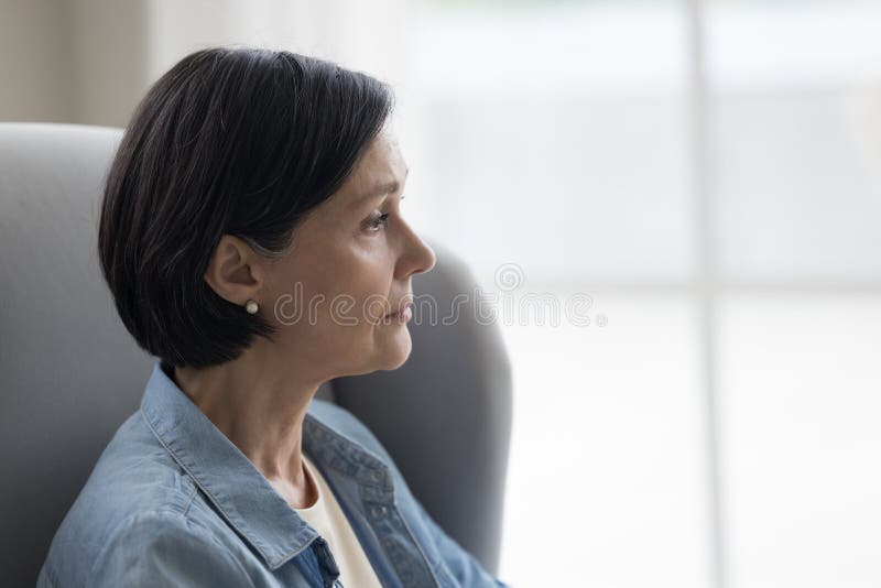 Sad Mature Black Haired Woman Looking Away In Deep Thoughts Stock Image