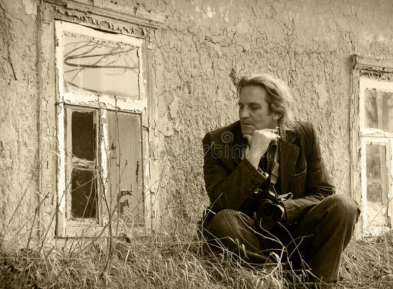 Sad Middle-aged Man Sitting in Front of an Abandoned House. Vintage ...