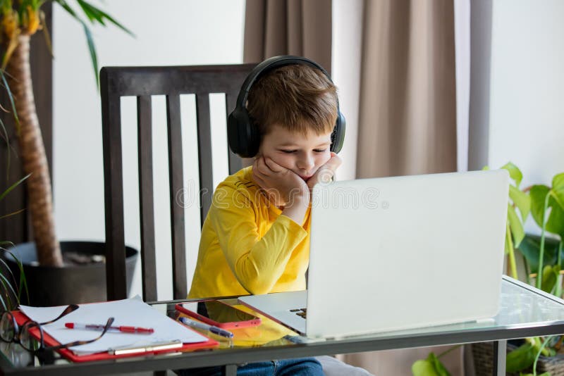 Sad Schoolboy in Headphones Learning Via Computer at Home Stock Photo ...