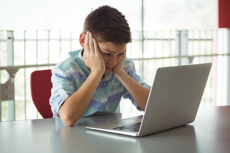 Sad Schoolboy Looking at Laptop in Library Stock Image - Image of ...