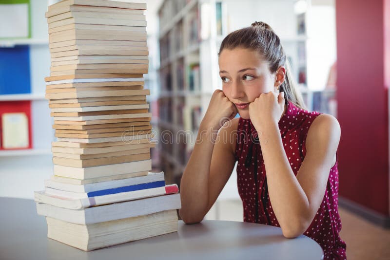 Sad Schoolgirl Looking at Stack of Books in Library Stock Image - Image ...