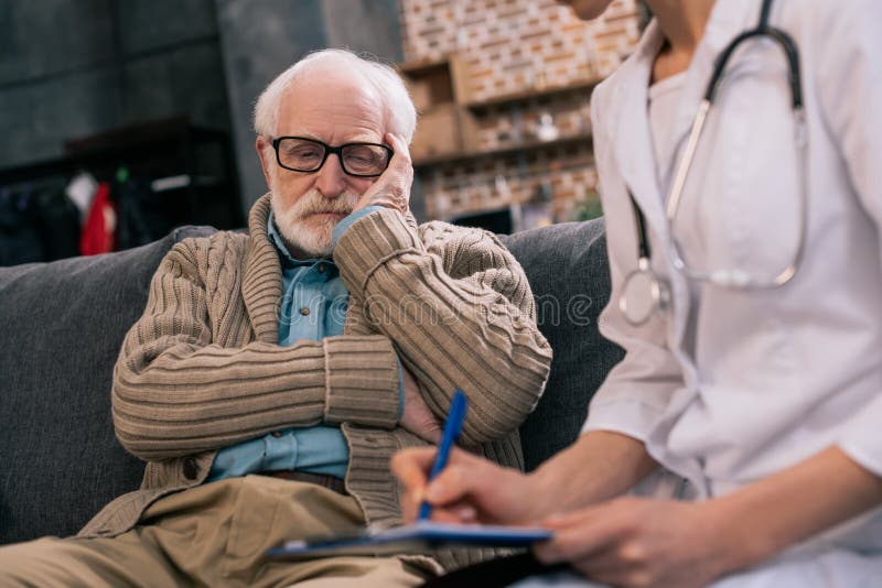 Sad Senior Man Looking at Doctor Writing Down Stock Image - Image of ...