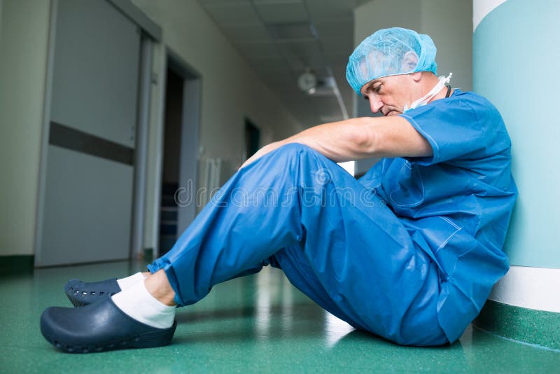 Sad Surgeon Sitting on Floor in Corridor Stock Image - Image of ...