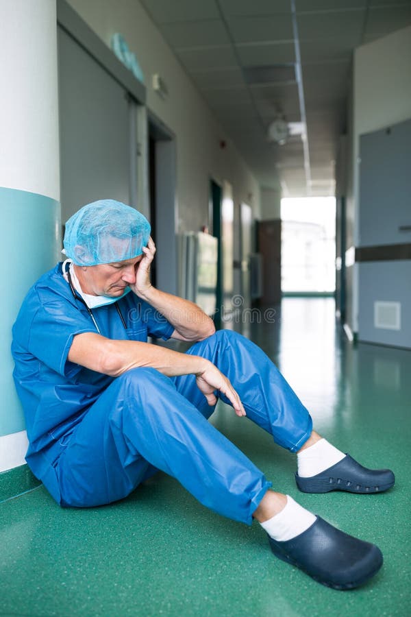 Sad Surgeon Sitting on Floor in Corridor Stock Photo - Image of ...