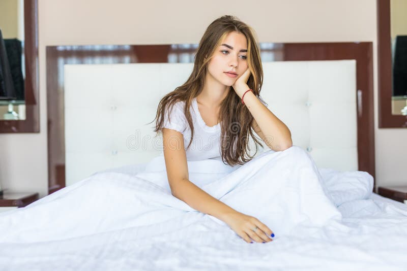 Sad Young Woman Sitting on the Bed at the Morning Stock Photo - Image ...