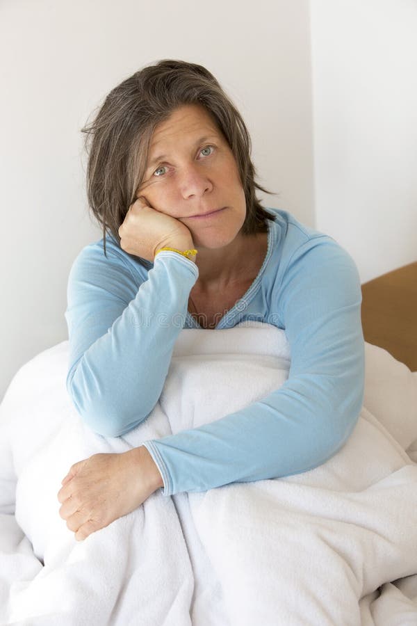Sad woman sitting in bed stock image. Image of retired - 54892603