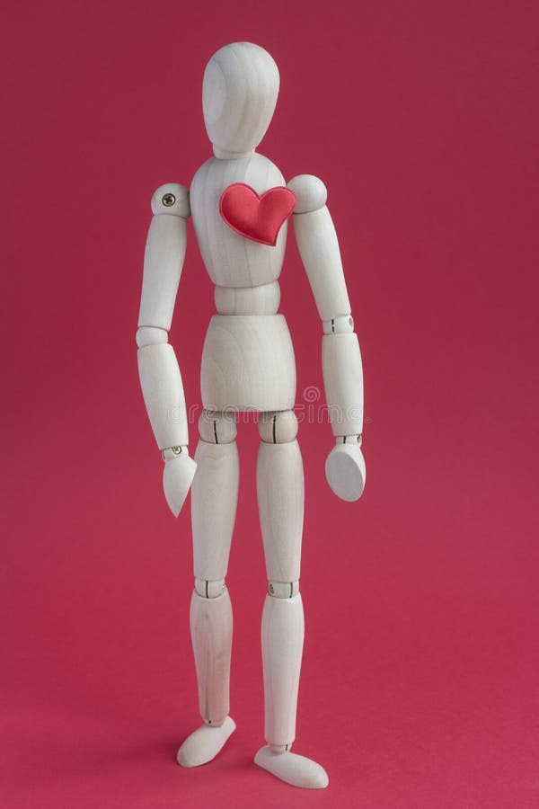 Wooden Puppet Human Siting on a Pile of Books with Red Plush Heart in ...