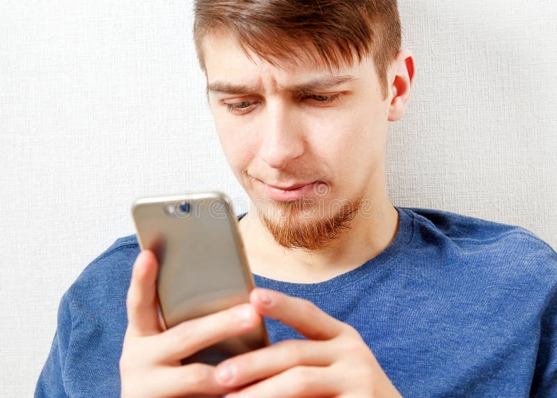 Sad Young Man with a Phone stock photo. Image of abuse - 221419746