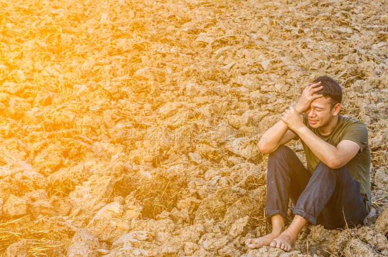 Sad Young Man Sitting in Barren Ground. with Sun Light Stock Photo ...