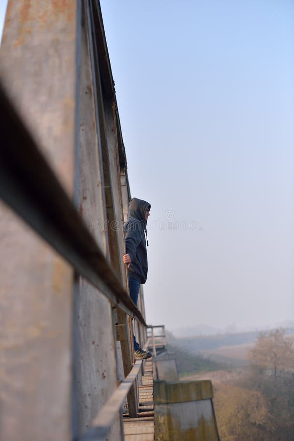 Sad Young Man Standing on the Edge of a Bridge. Looking Away Thinking ...