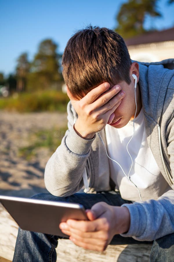 Sad Young Man with a Tablet Stock Image - Image of headphones, nature ...