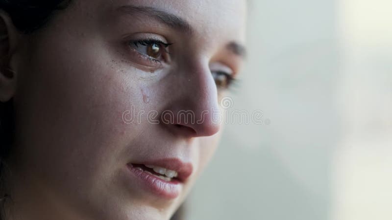 Sad Young Woman Crying while Looking through the Window at Home. Stock ...