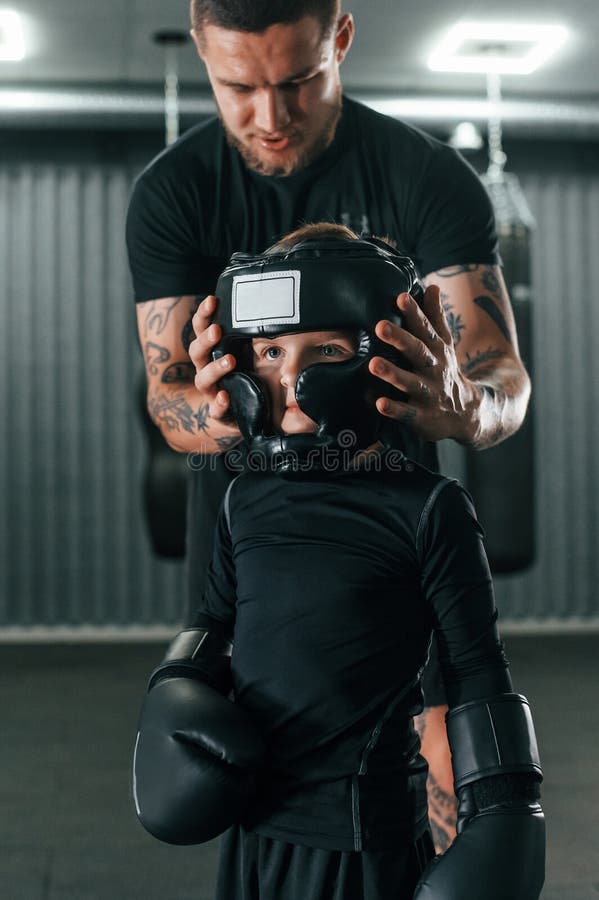 Safety of the Head. Coach is Teaching the Boy Box Techniques Indoors ...