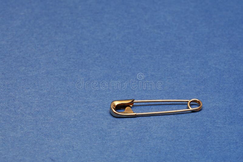 Safety Pin in Gold on Blue Background Stock Image - Image of material ...