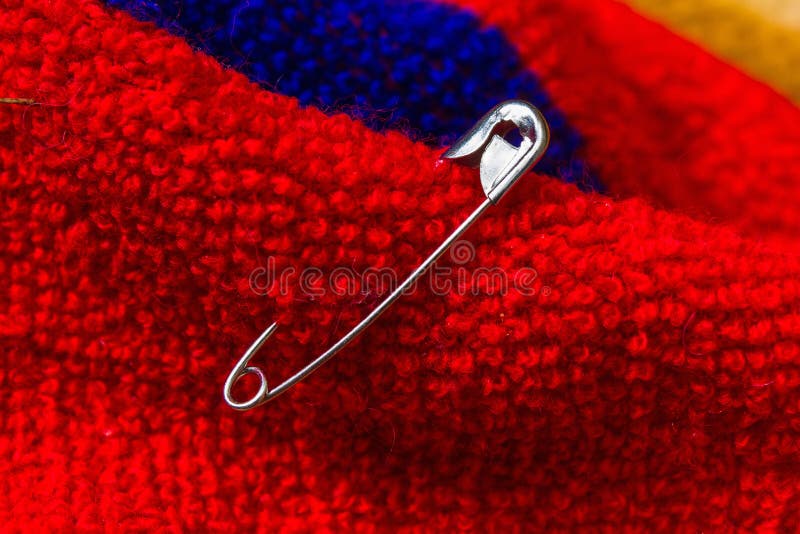 Safety pin pinned to the texture fabric Safety pin pinned to the ...