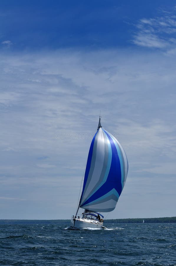 Sailboat with Blue Spinnaker Sail Stock Photo - Image of lake, vertical ...