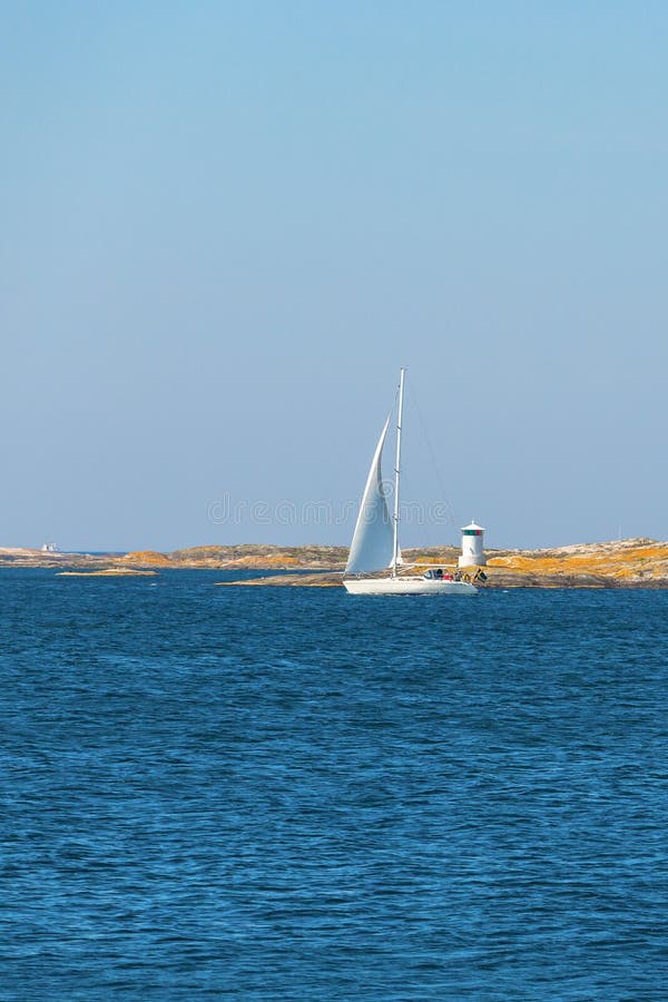 Sailboat with a Lighthouse on the Rocks Stock Photo - Image of ...