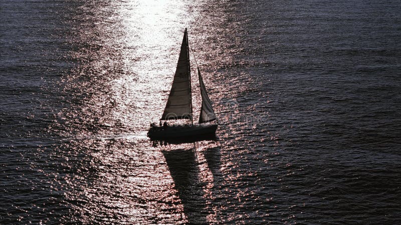 Sailboat Sailing on Calm Water Reflecting the Sunset Stock Photo ...