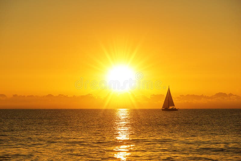 A Sailboat Sailing with the Sunrise Sun Stock Photo - Image of ...