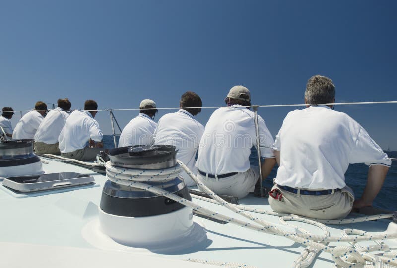 Sailing Crew Sitting on Side of Yacht on Ocean Back View Stock Photo ...