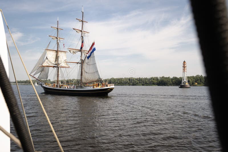 Sailing Ship with Dutch Flag and a Lighthouse in Distance Stock Photo ...