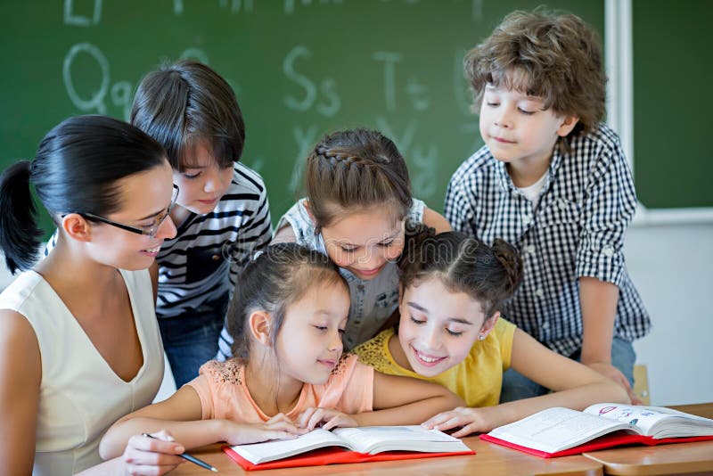 Niños De La Escuela Primaria Que Se Sientan En Piso De La Sala De Clase Imagen De Archivo