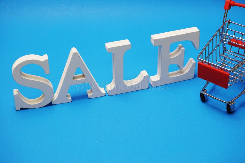 Sale and Mini Trolley Cart on Blue Background Stock Photo - Image of ...