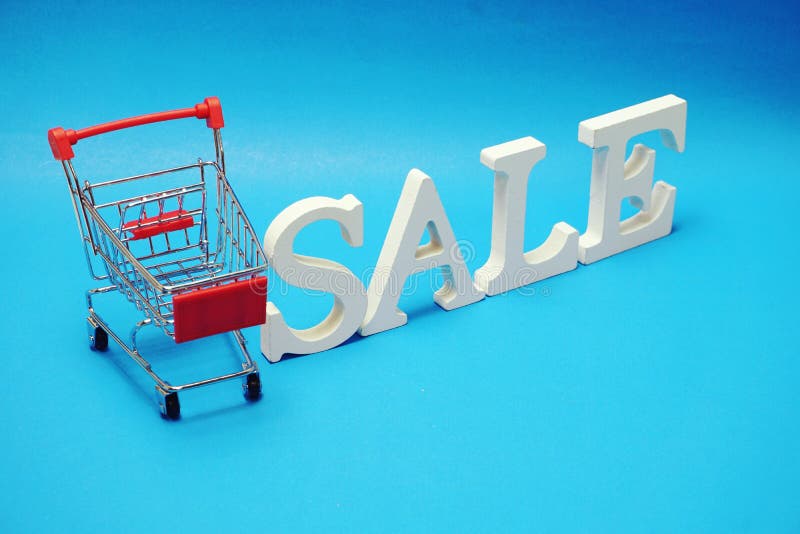 Sale and Mini Trolley Cart on Blue Background Stock Photo - Image of ...