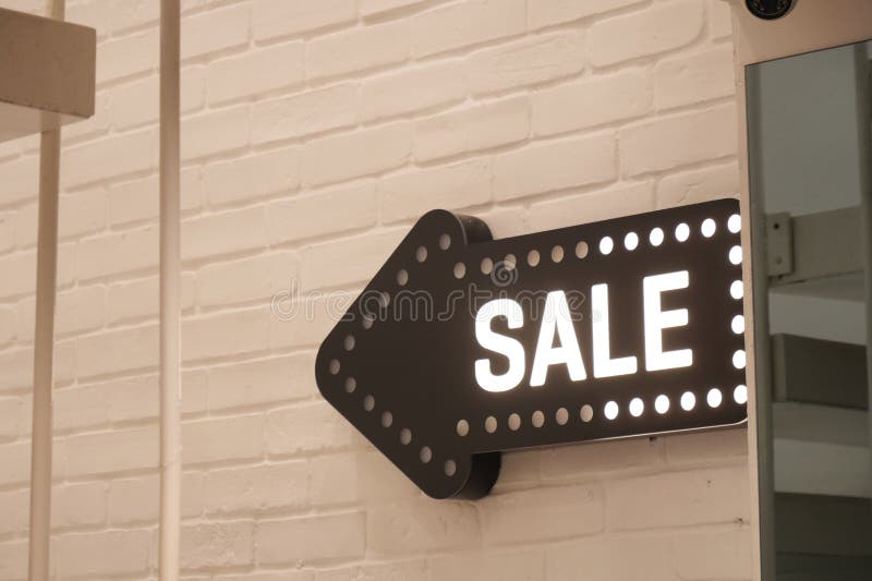Sale Sign with Arrow Hanging on Wall Stock Photo - Image of buying ...