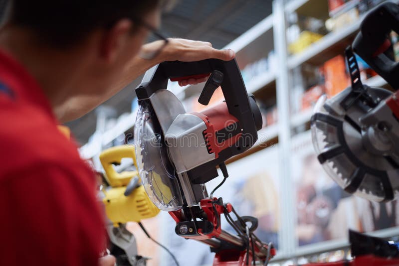 Sales Assistant of a Construction Store Stands Near a Shelf with Power ...