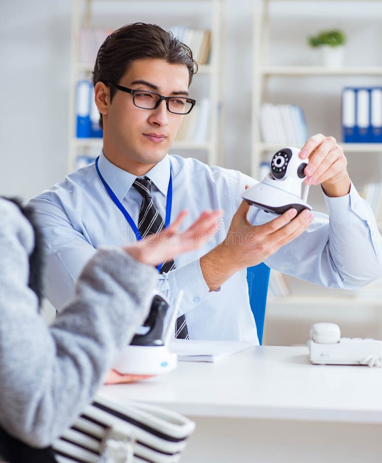 Sales Assistant Showing Cameras To Client in Shop Stock Image - Image ...