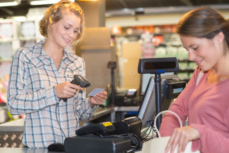 Sales Assistant Working at Check-out Stock Photo - Image of scannning ...