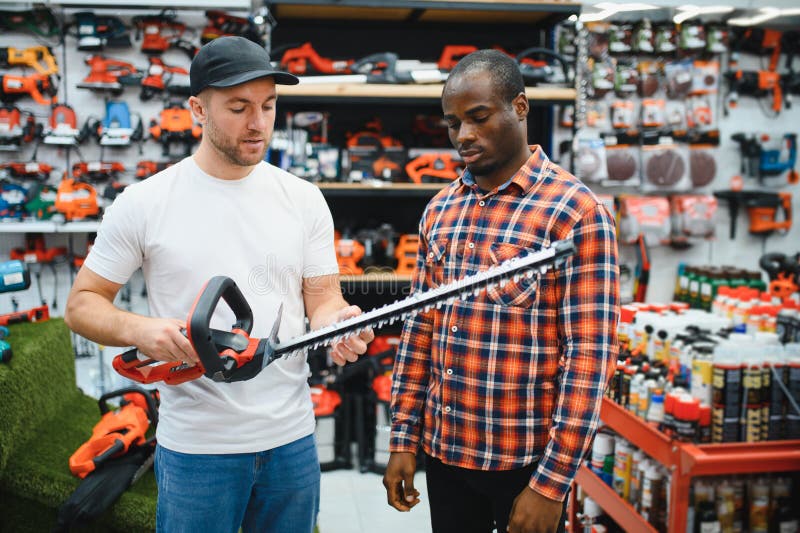 The Sales Consultant Helps the Client Chooses a Brushcutter in a ...
