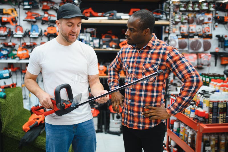 The Sales Consultant Helps the Client Chooses a Brushcutter in a ...