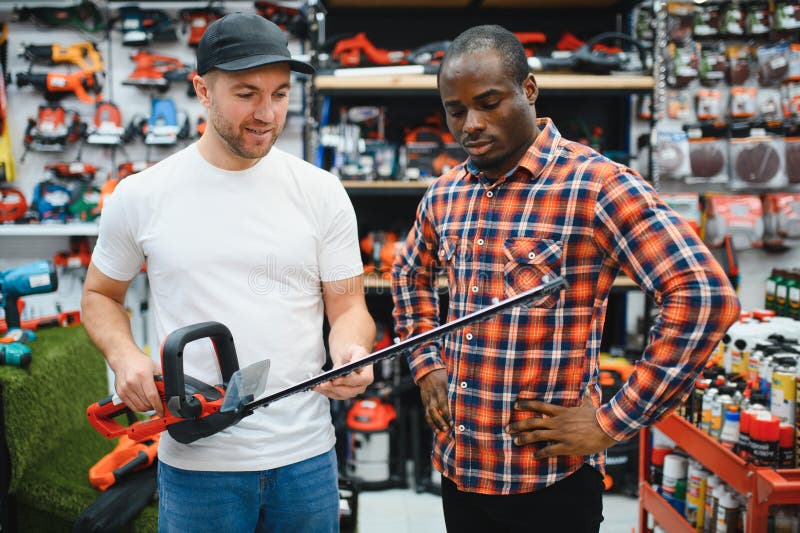 The Sales Consultant Helps the Client Chooses a Brushcutter in a ...