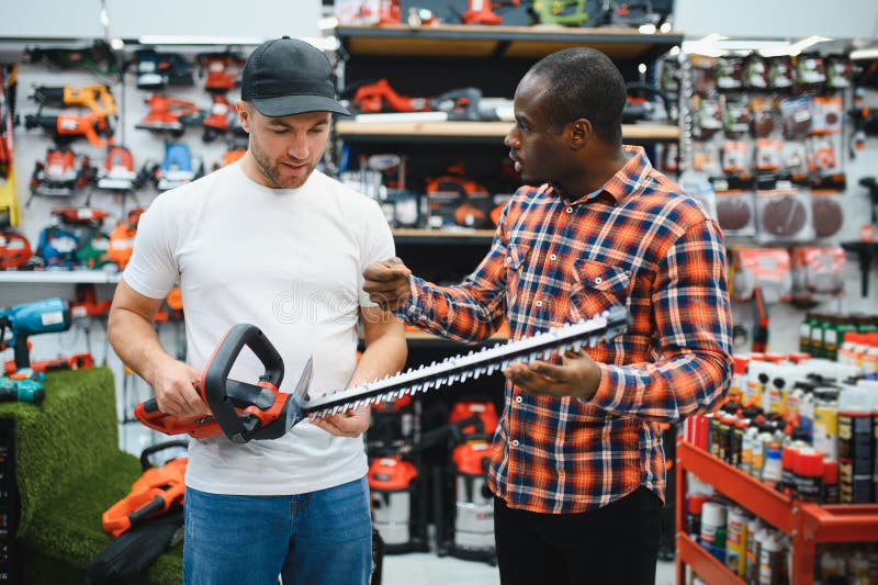 The Sales Consultant Helps the Client Chooses a Brushcutter in a ...