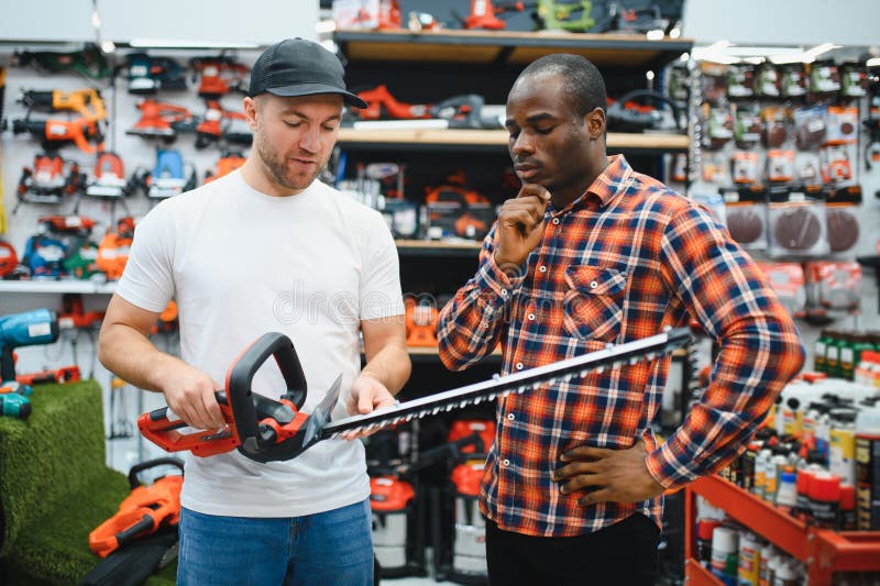 The Sales Consultant Helps the Client Chooses a Brushcutter in a ...