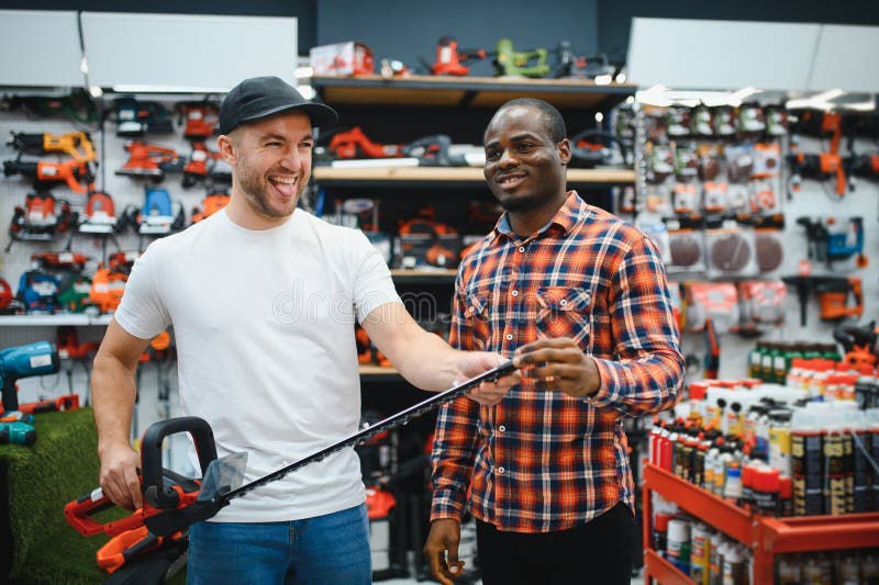 The Sales Consultant Helps the Client Chooses a Brushcutter in a ...