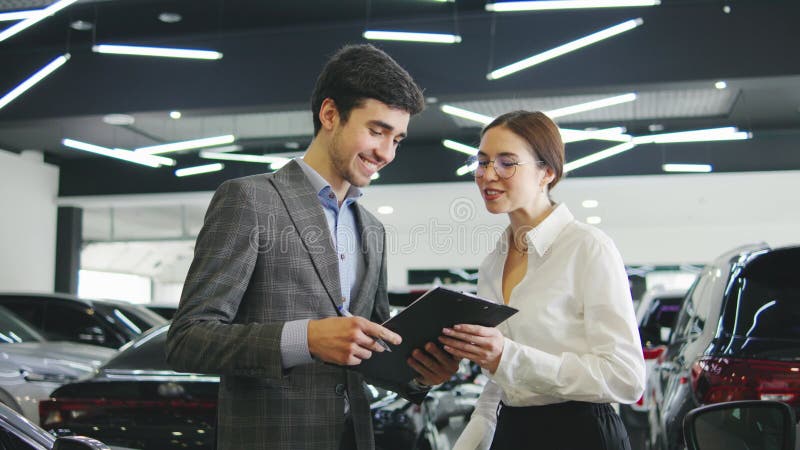 Sales Representative Discussing Vehicle Options with a Customer in a ...