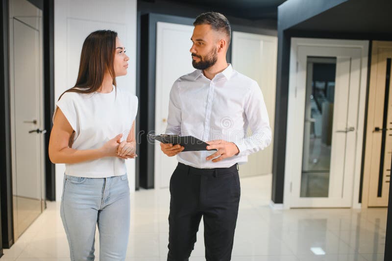 A Salesman Advises a Female Customer on the Choice of Interior Doors in ...