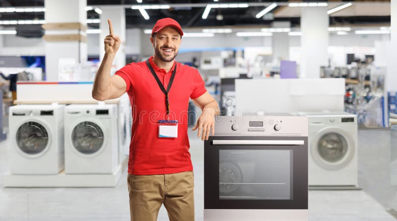 Salesman with Electrical Appliances Smiling and Pointing Up in a Store ...